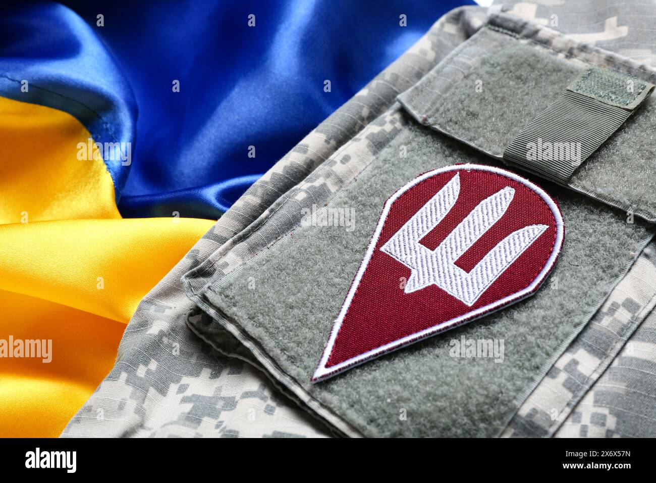 Badge with trident on military uniform and flag of Ukraine, closeup ...