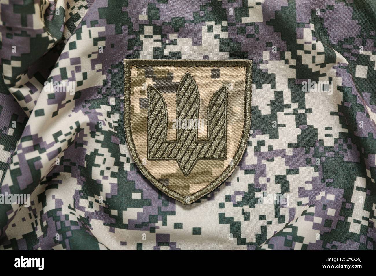 Military badge of Ukrainian army with trident on camouflaged uniform ...