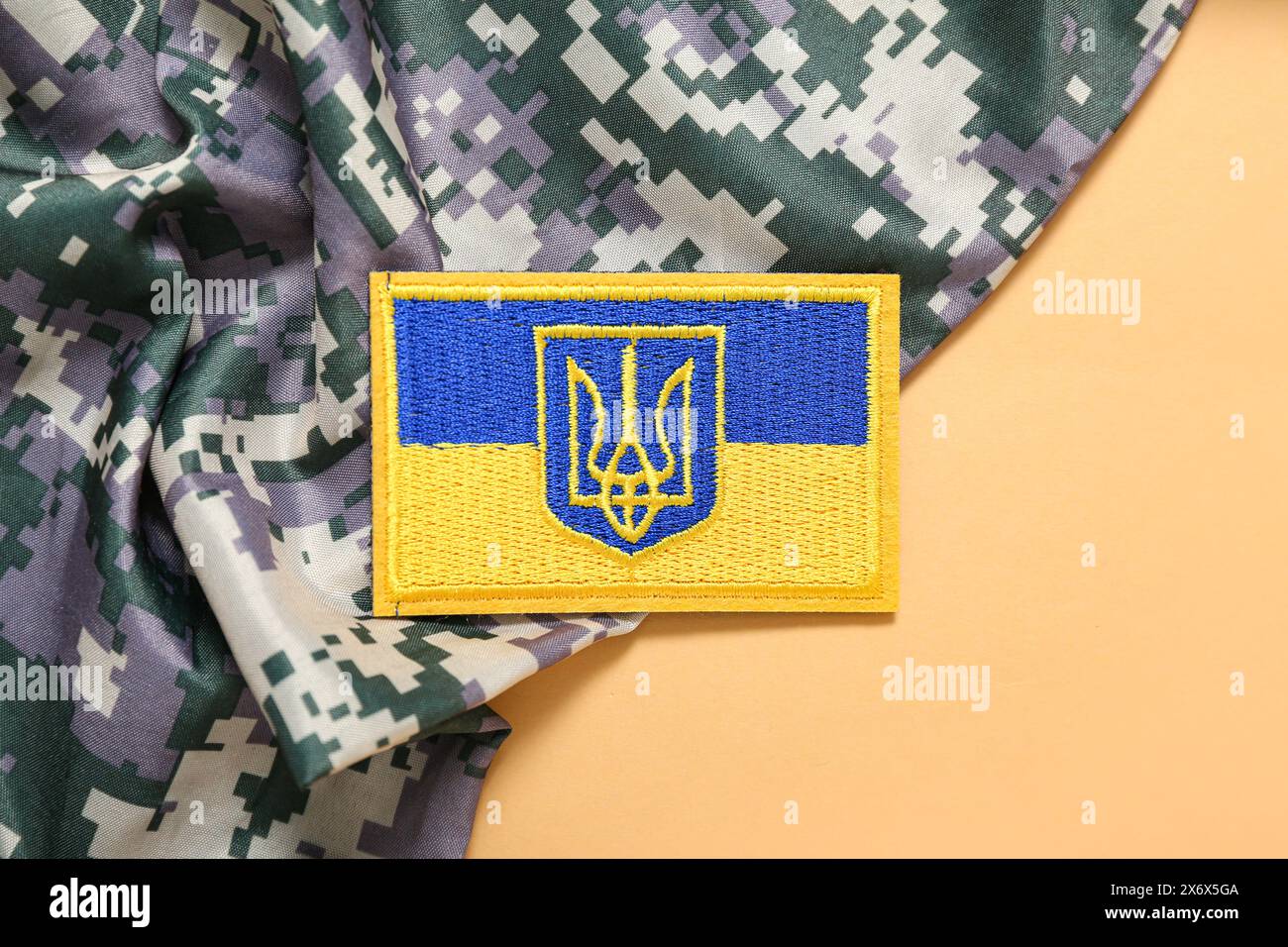 Military badge of Ukrainian army with trident and camouflaged uniform ...