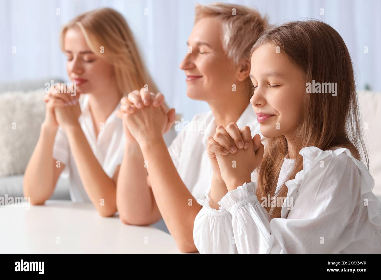 Little girl with her mom and grandmother praying at home Stock Photo ...