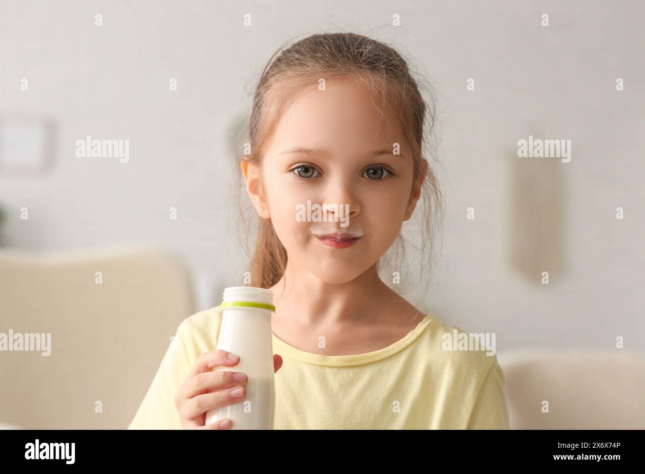 Cute little girl drinking yogurt at home Stock Photo - Alamy