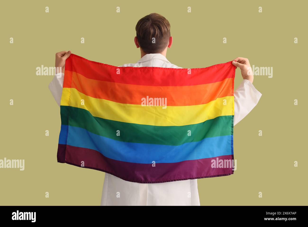 Male dentist with LGBT flag on green background, back view Stock Photo ...