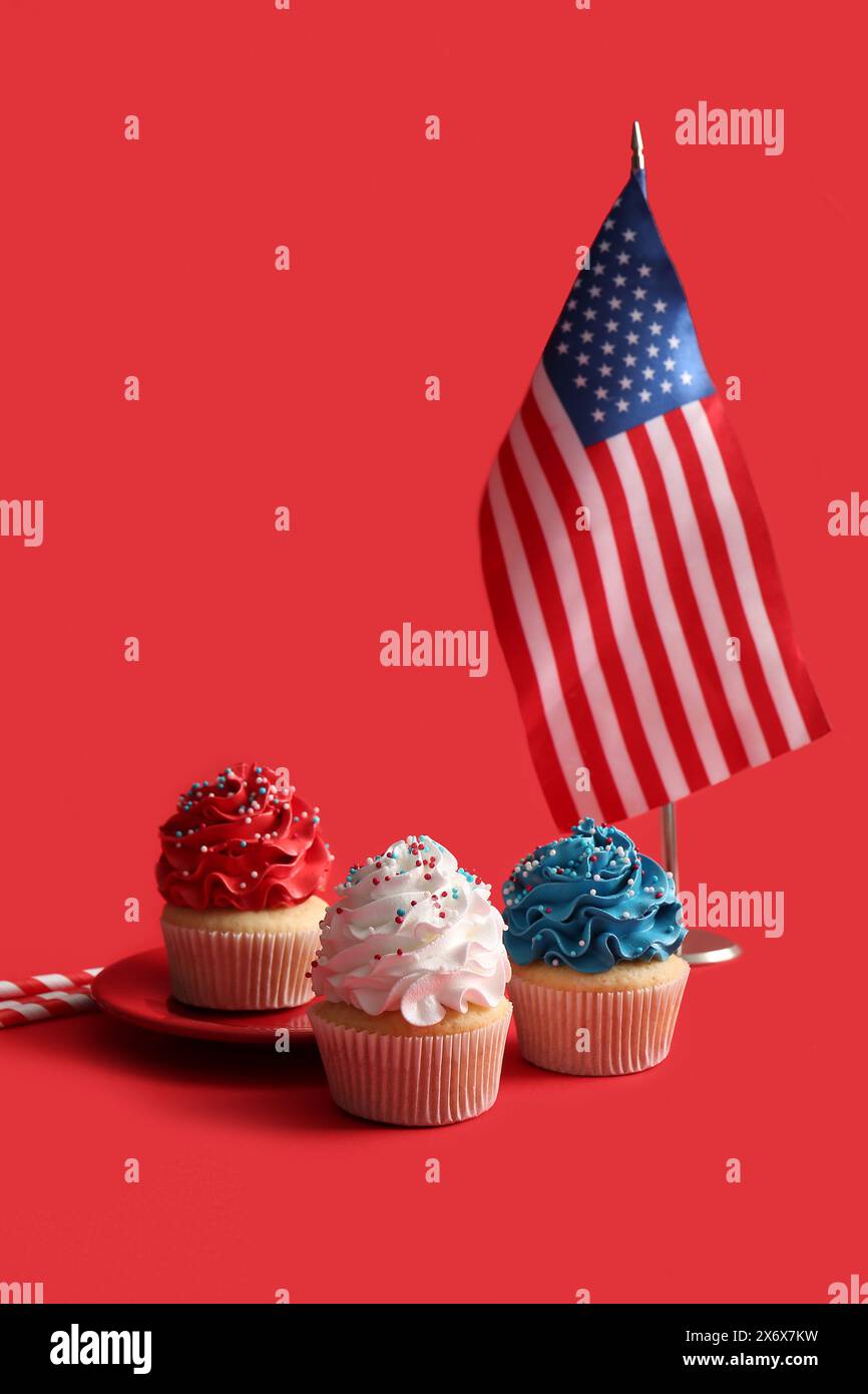 Tasty patriotic cupcakes with USA flag on red background. American ...