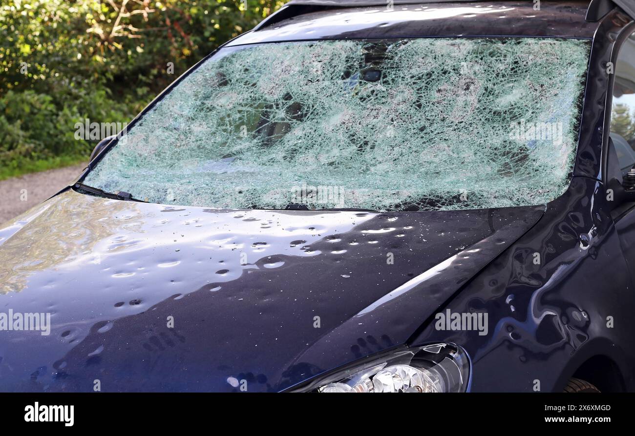 Hail damage to a car. Large hailstones have completely destroyed a car ...