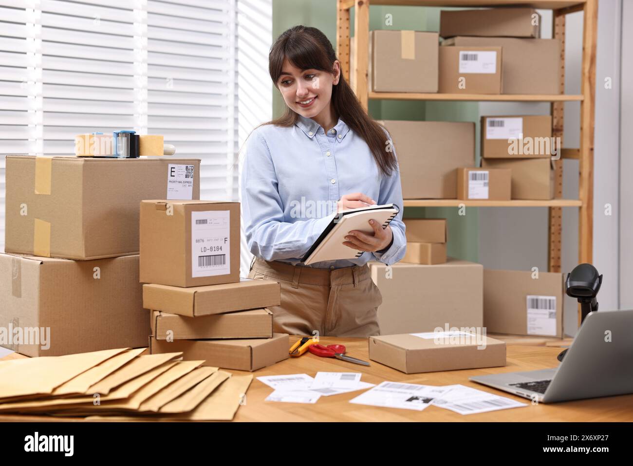 Parcel packing. Post office worker writing notes indoors Stock Photo ...