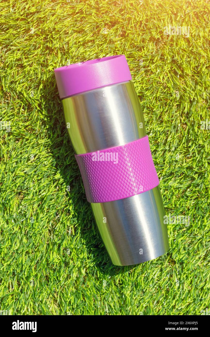 The Stainless Thermal Flask On The Green Grass Background With Sunlight ...