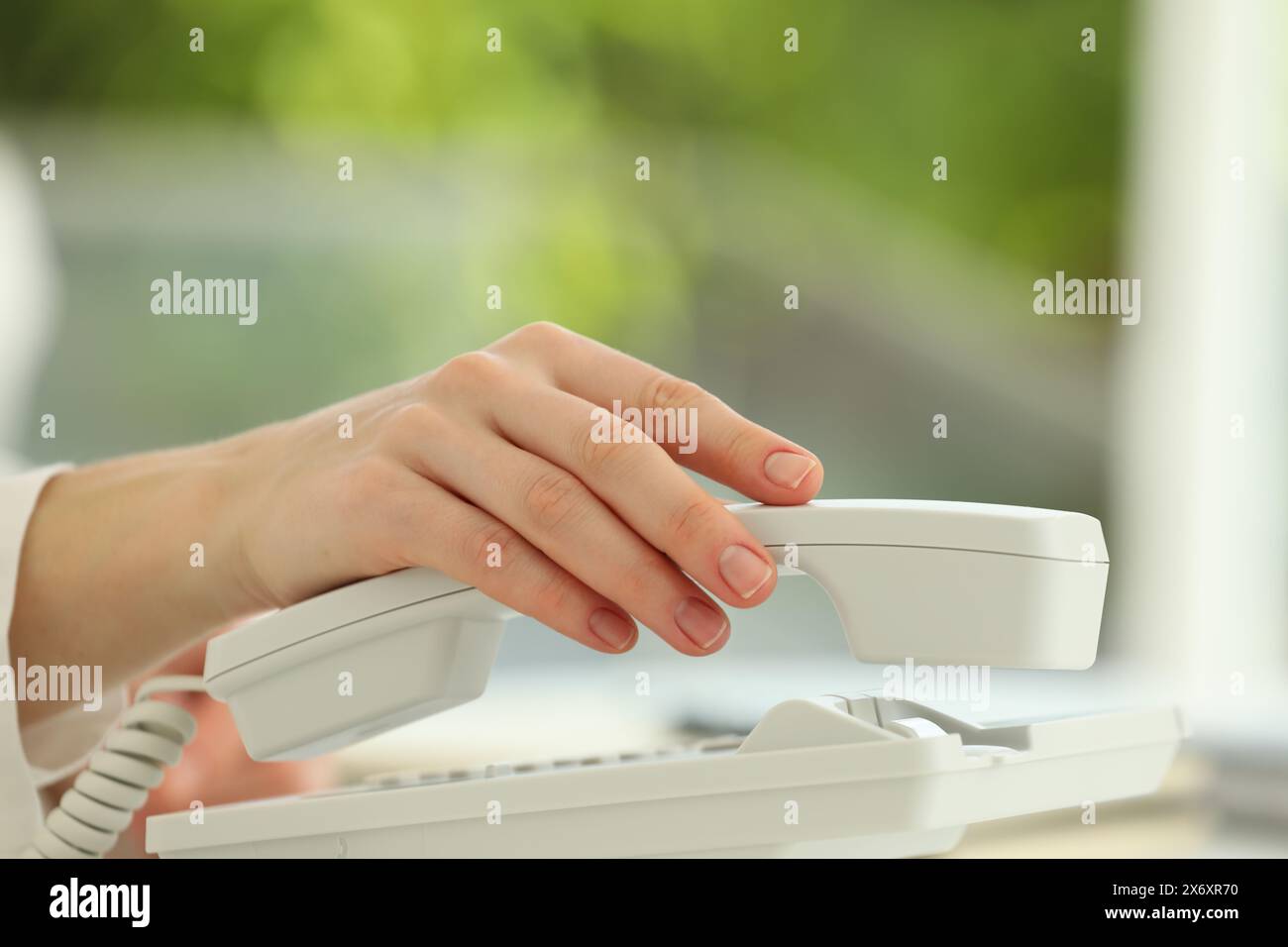 Assistant taking telephone handset on blurred background, closeup Stock ...