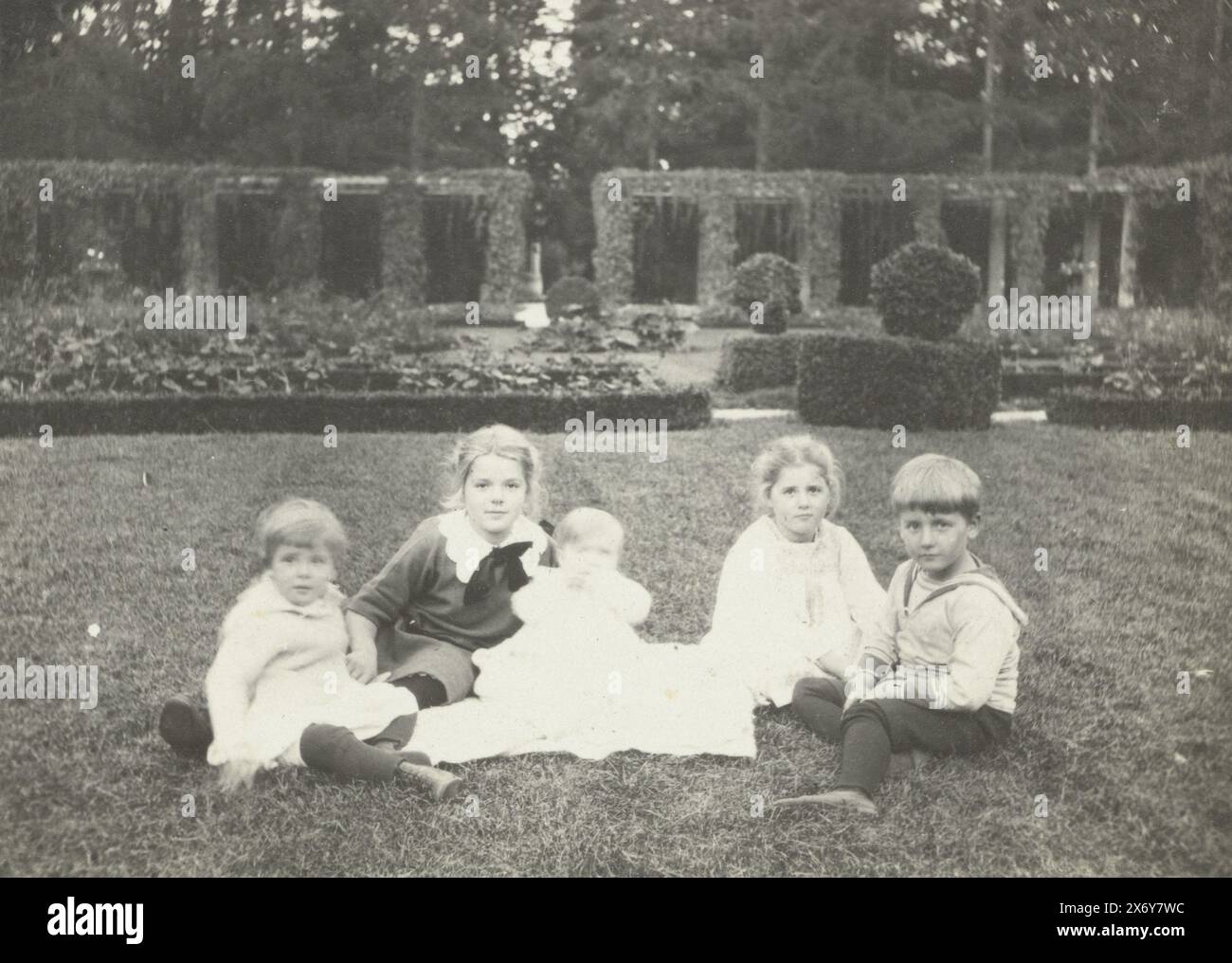 Portrait of children sitting on a field, Five children posing while ...