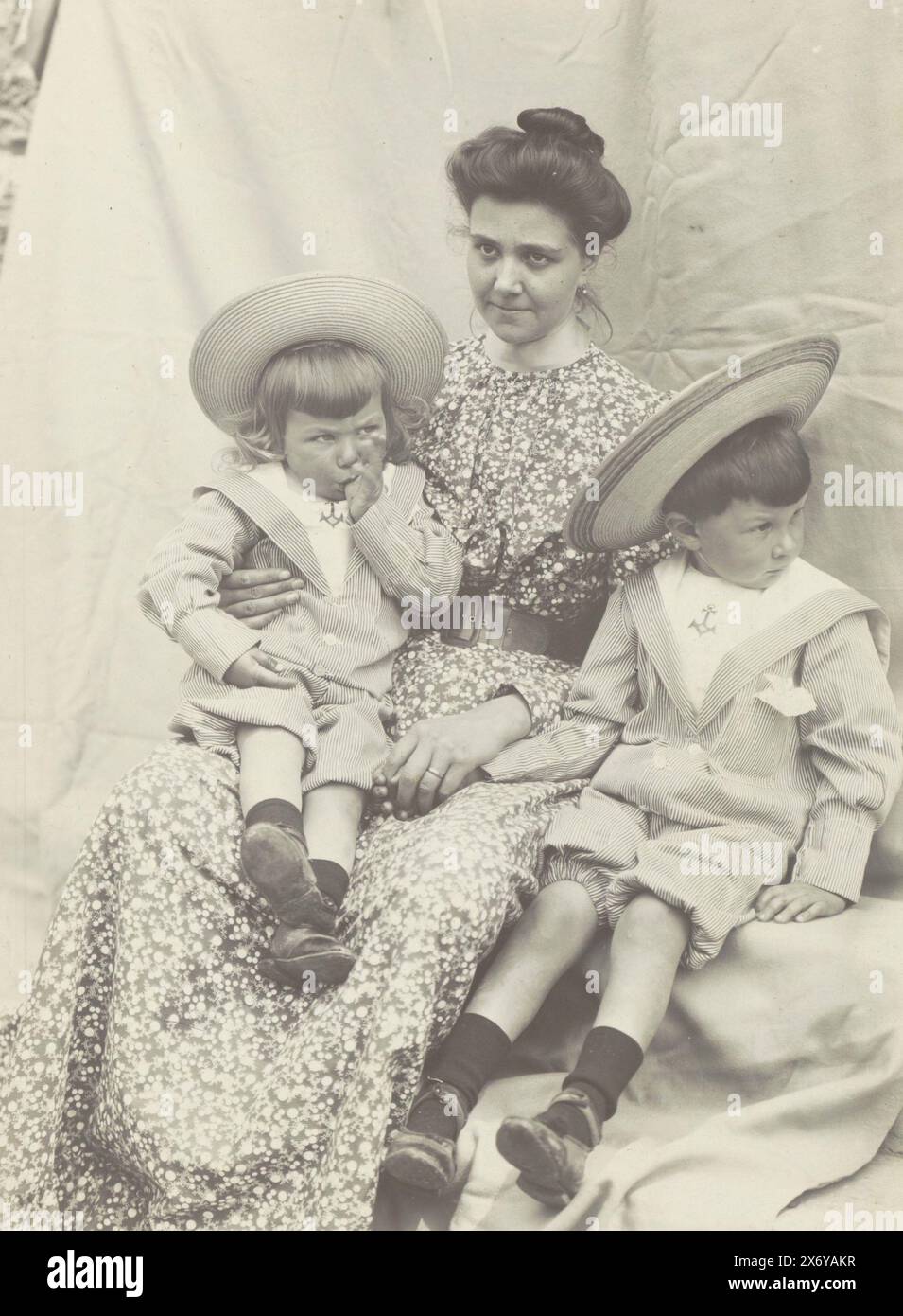 Portrait of a woman with two children wearing sun hats and sailor suits ...