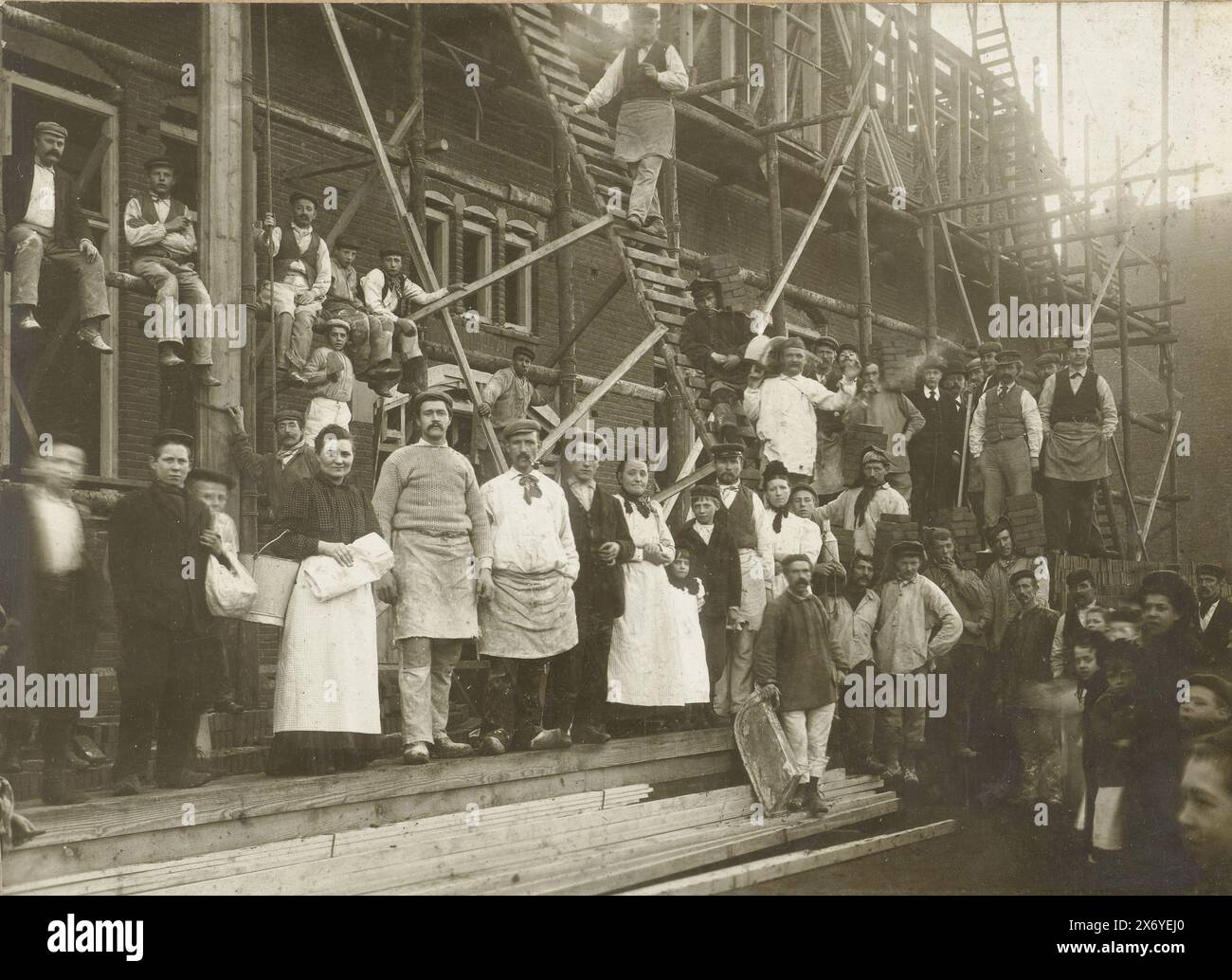 Group portrait of workers at a house under construction, photograph ...