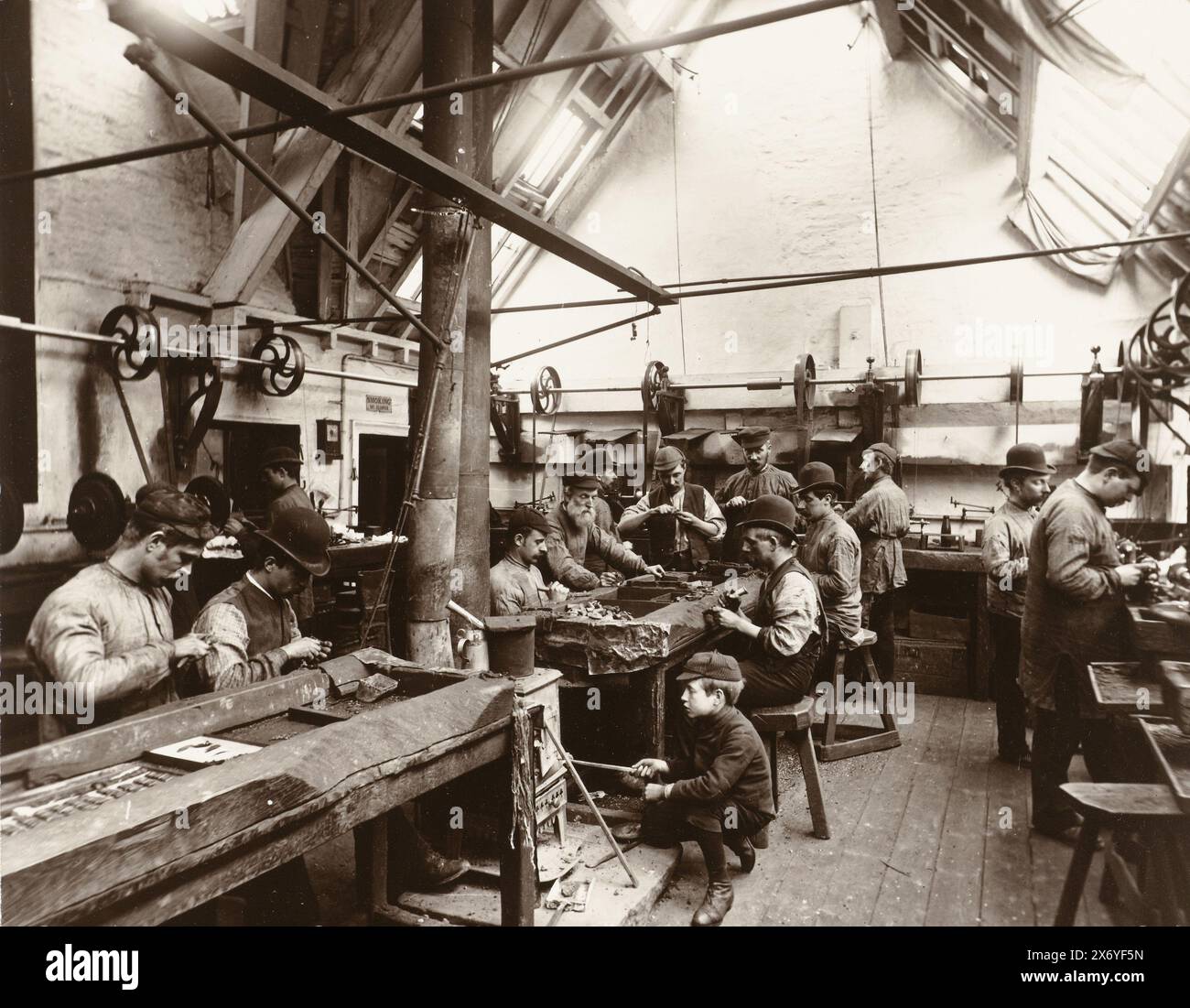 Workers around a workbench in a factory, photograph, Frank Meadow ...