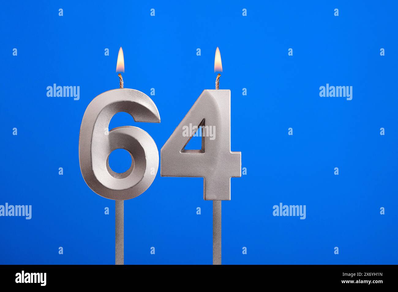 Birthday number 64 - Candle lit on blue background Stock Photo - Alamy