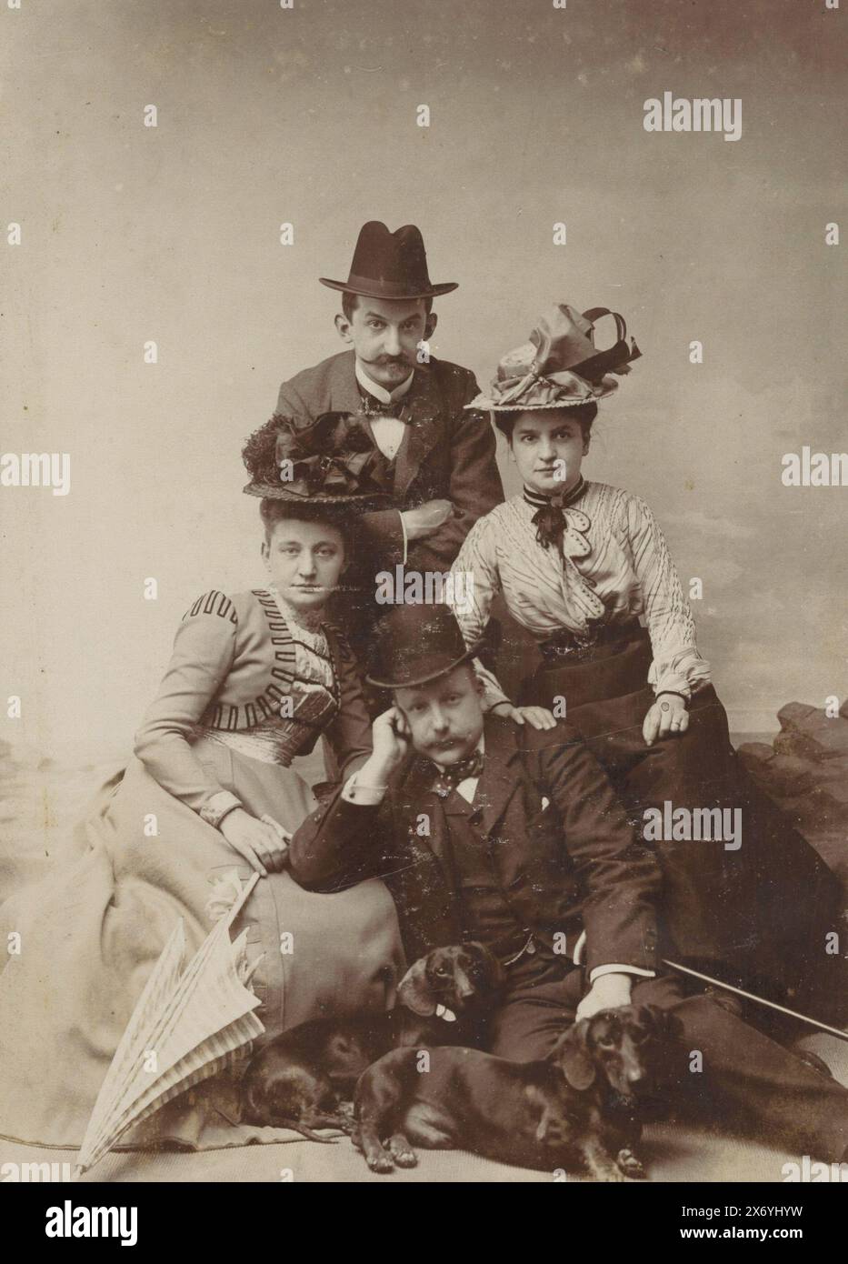 Studio portrait of four unknown men and women with two dachshunds ...