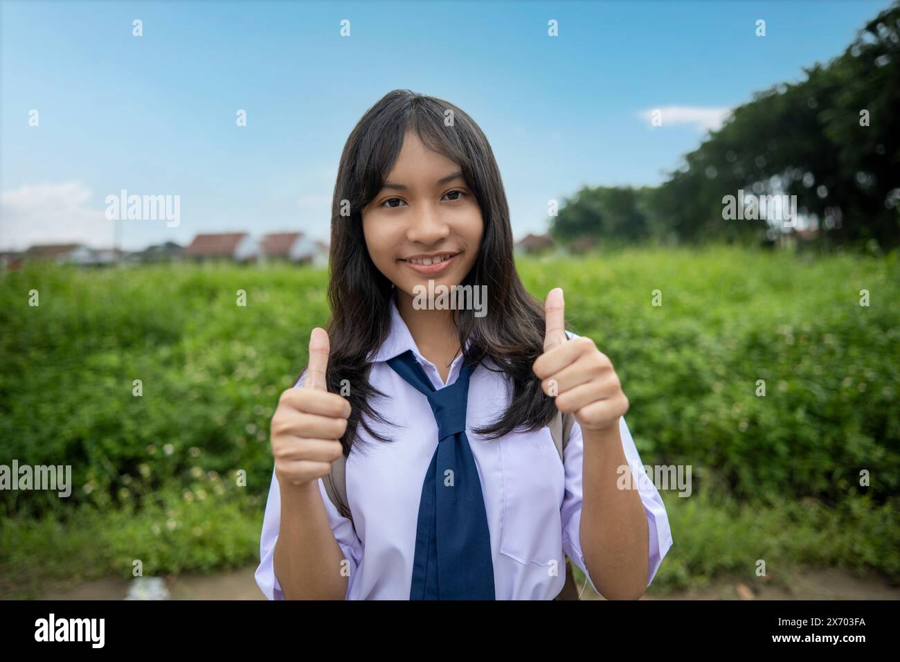 Portrait of Asian Junior High School student girl in uniform carrying ...