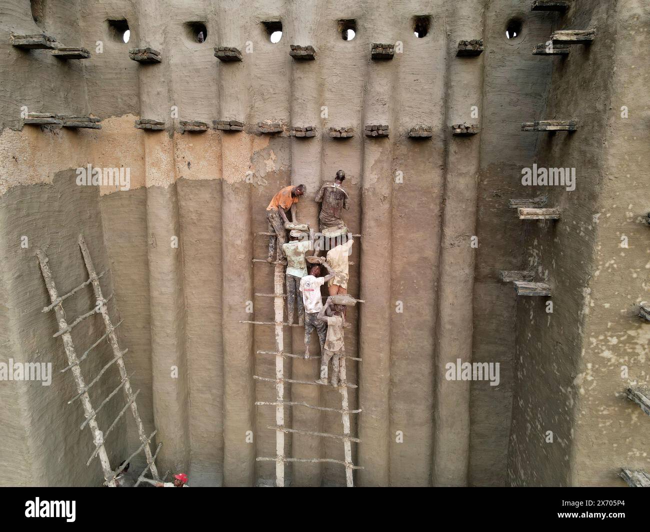 Malians take part in the annual re-plastering of the world's largest ...