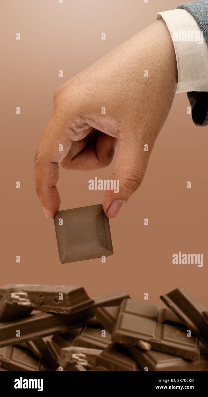 Close up human hand holding chocolate bar, concept of giving on world ...