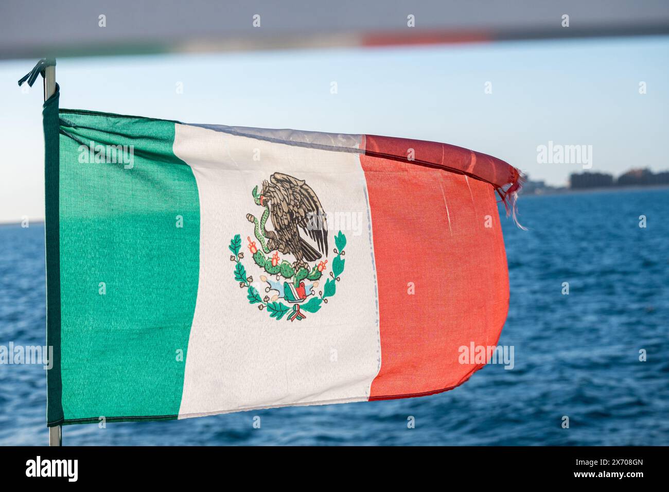 Photo of a Mexican flag flying with the Gulf of California in the ...