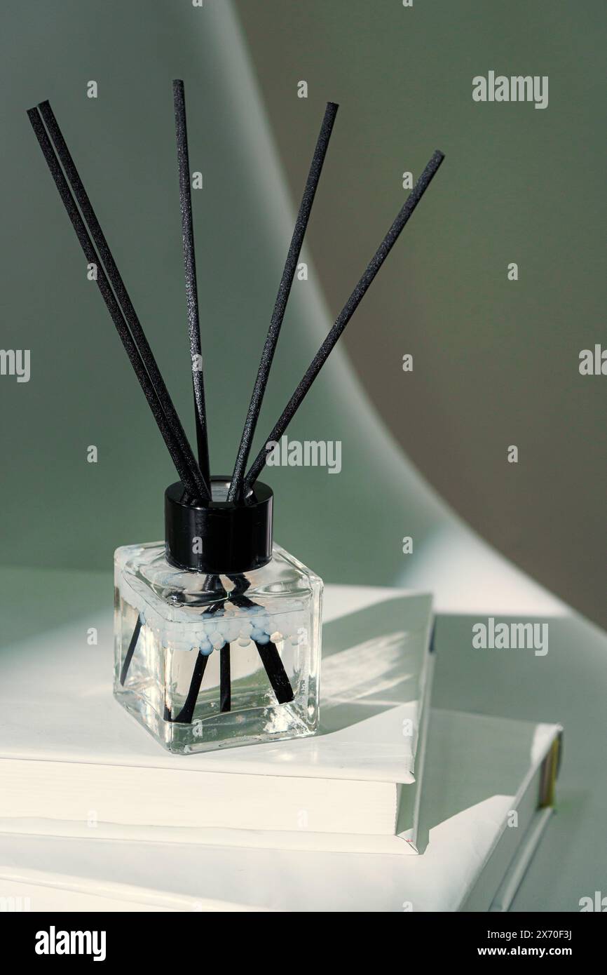 Liquid home perfume in glass diffuser with sticks on chair Stock Photo ...