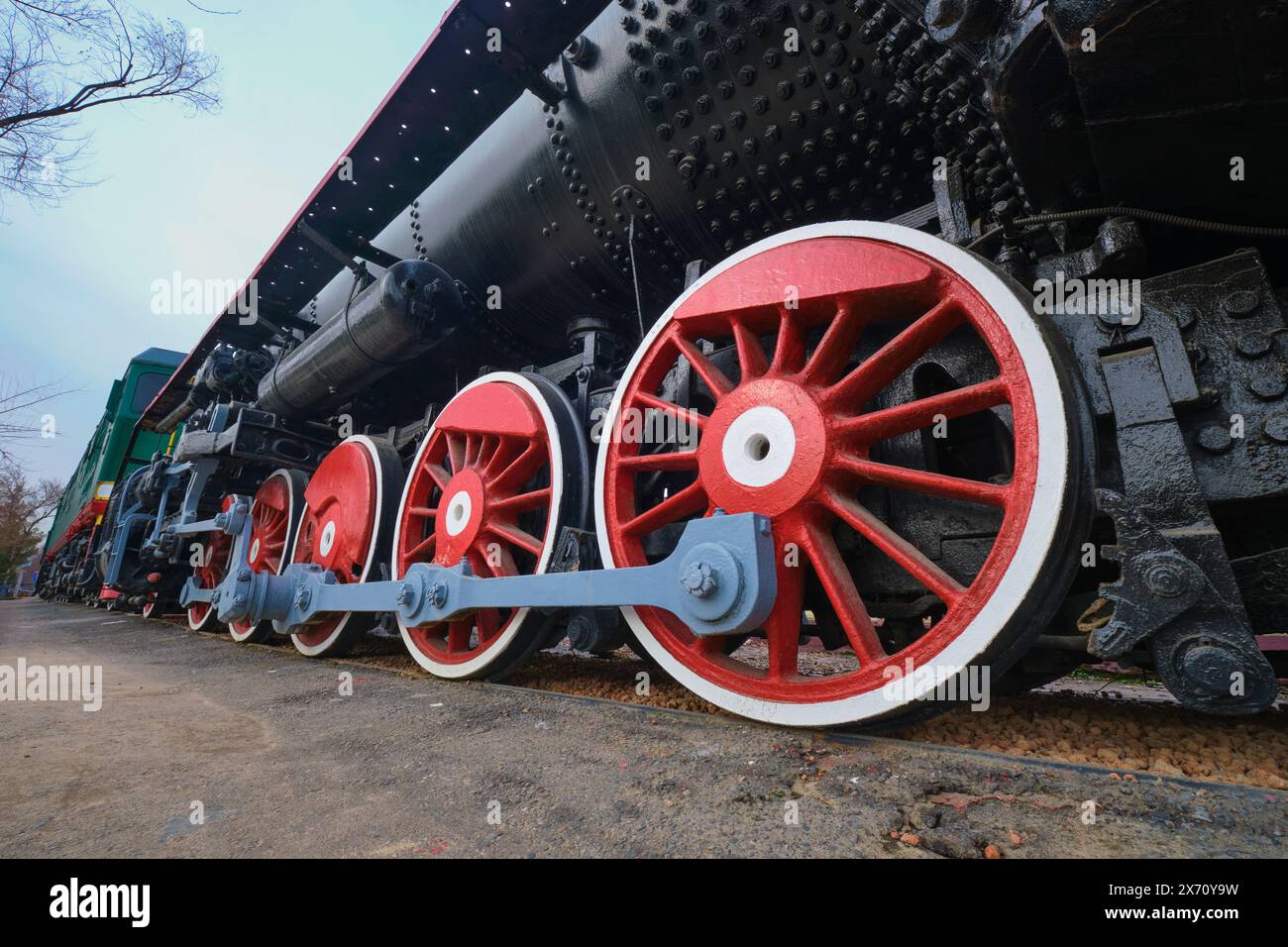 Close up of the huge, red, steel wheels on a black, steam locomotive ...