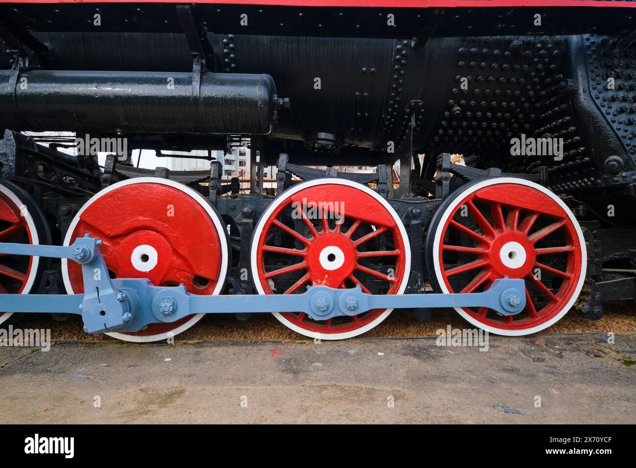 Close up of the huge, red, steel wheels on a black, steam locomotive ...