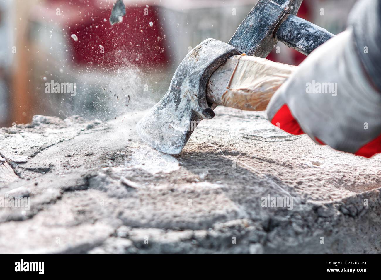 Worker using a sledgehammer to cut a stone with cement. Construction ...