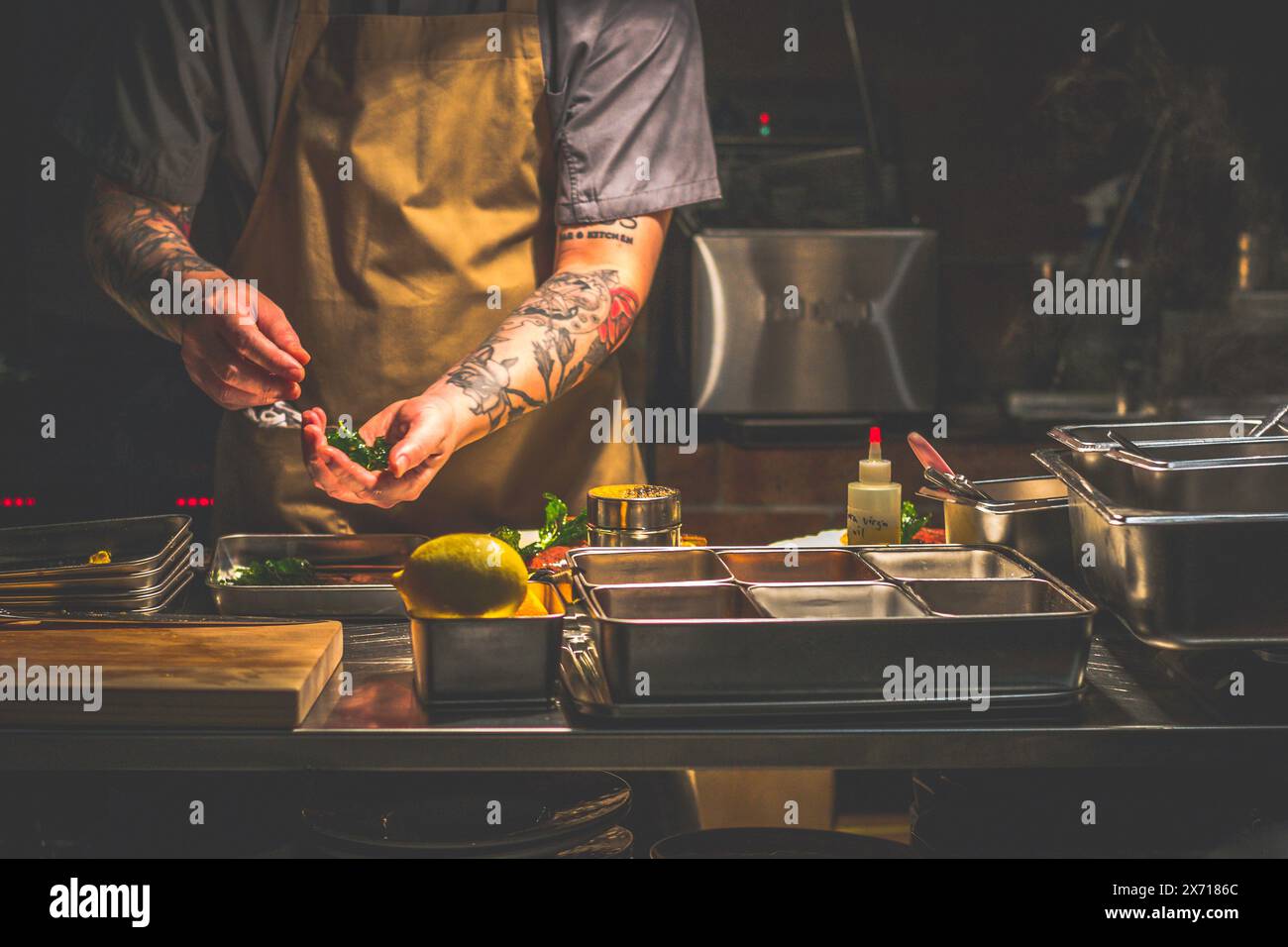 Chef with tattoos workinng in an open fire open kitchen in Singapore ...