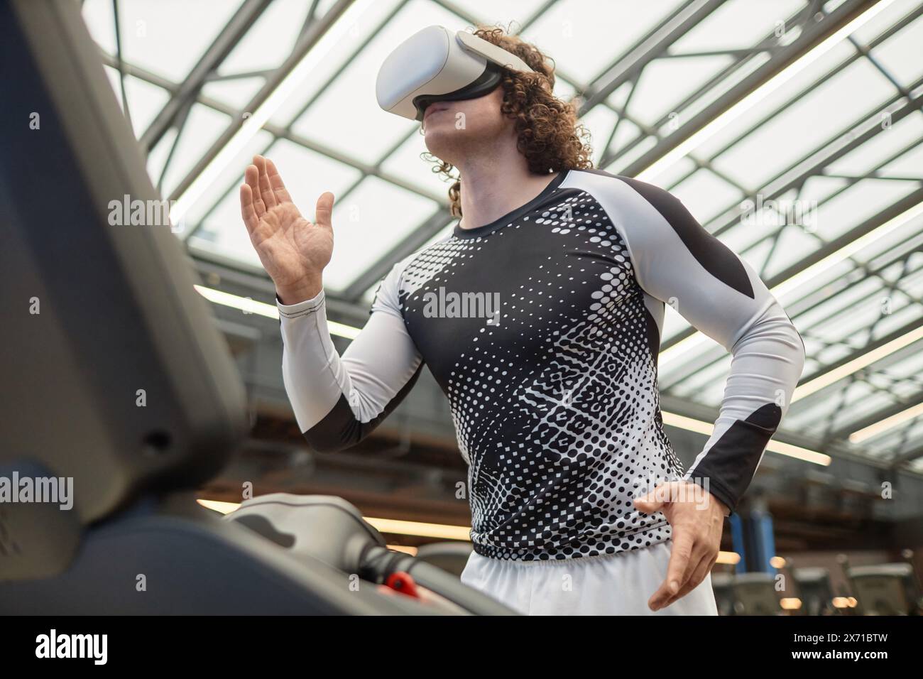 Action side view of muscular young man running on treadmill with VR ...