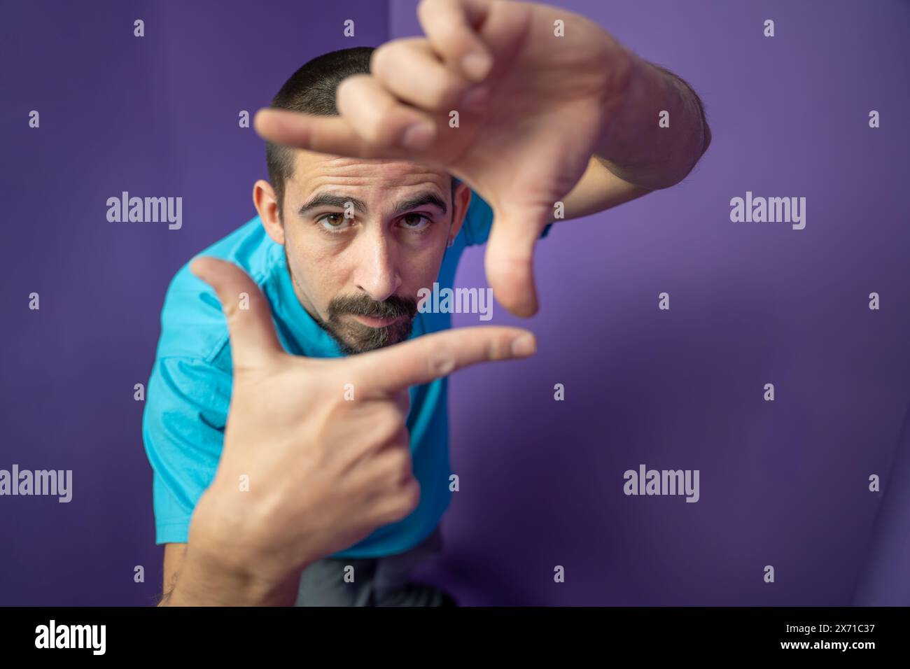 Man doing frame using hands and fingers, isolated over purple ...