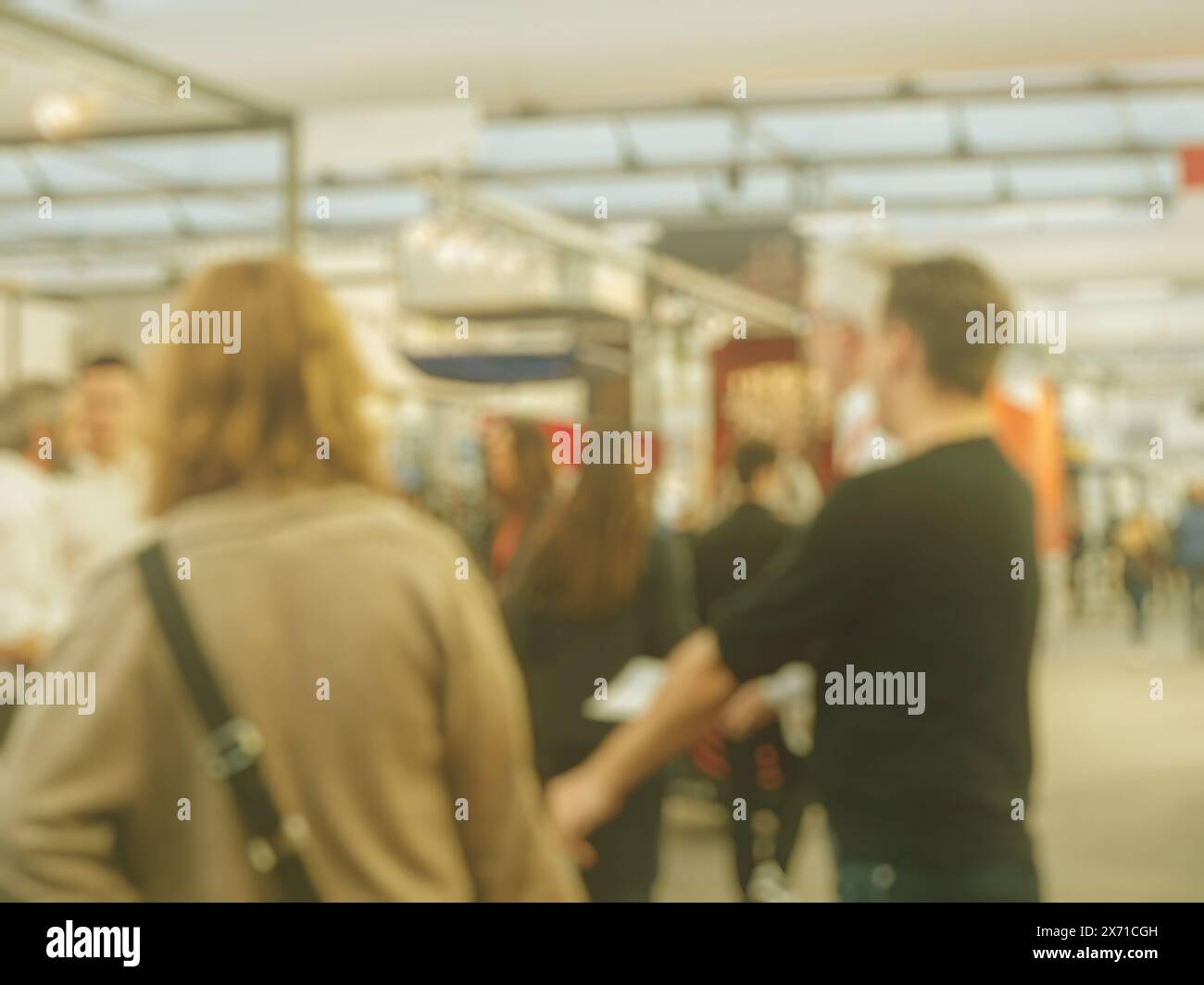 Out-of-focus silhouettes at a convention center depict people closing a ...