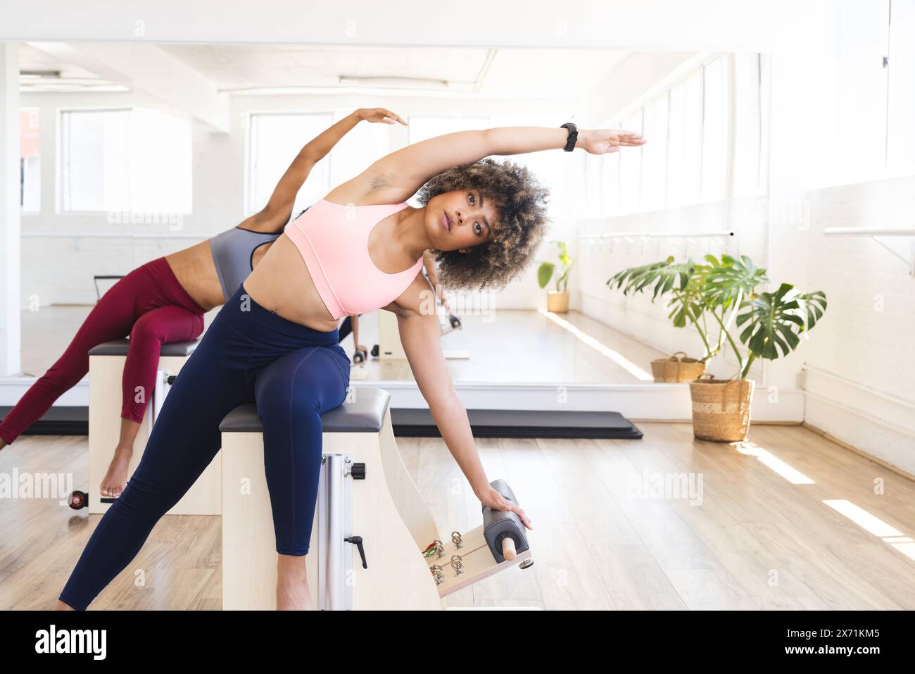 At studio biracial women exercising, wearing athletic gear Stock Photo ...