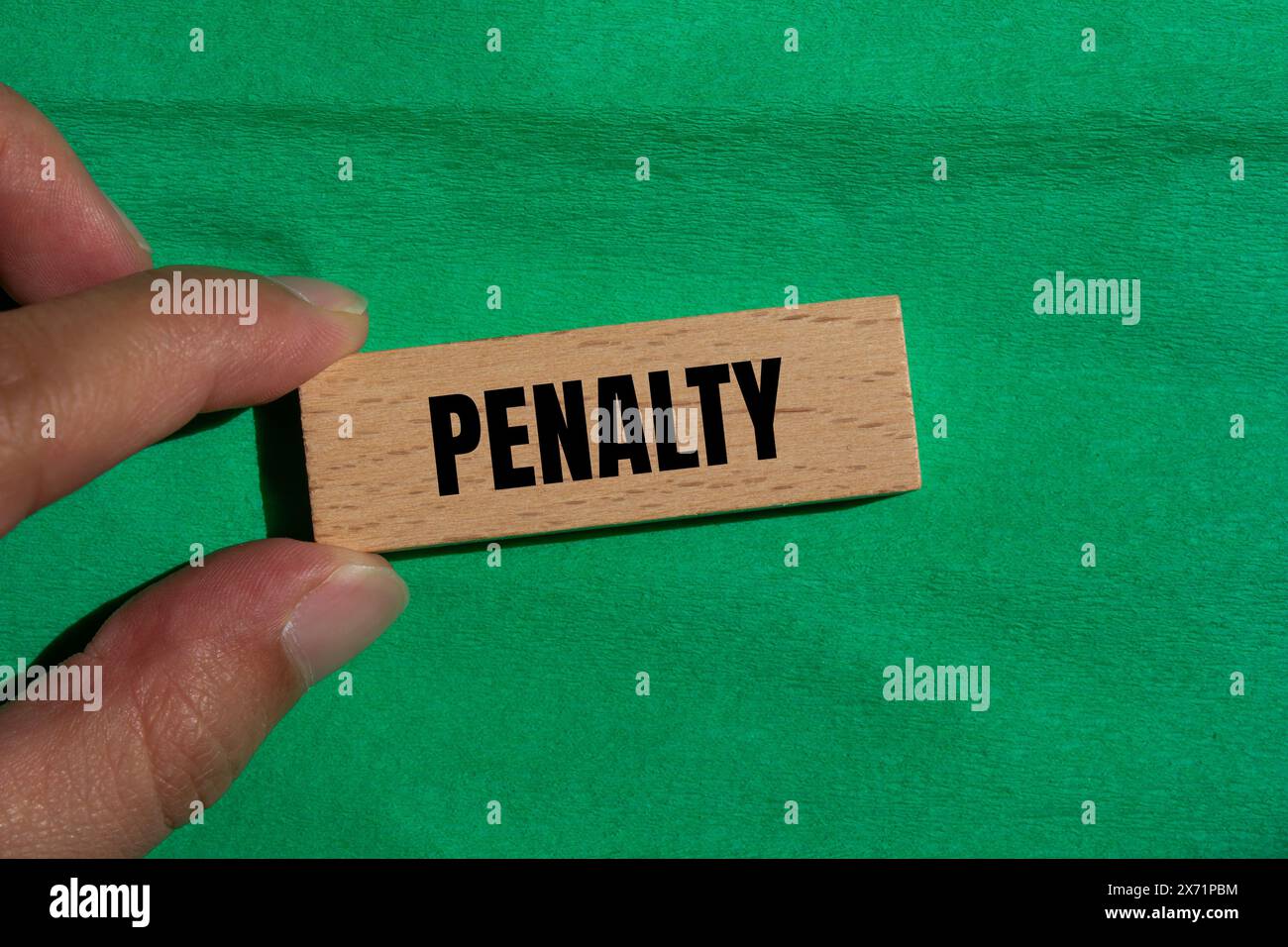 Penalty word written on wooden block with green background. Conceptual ...