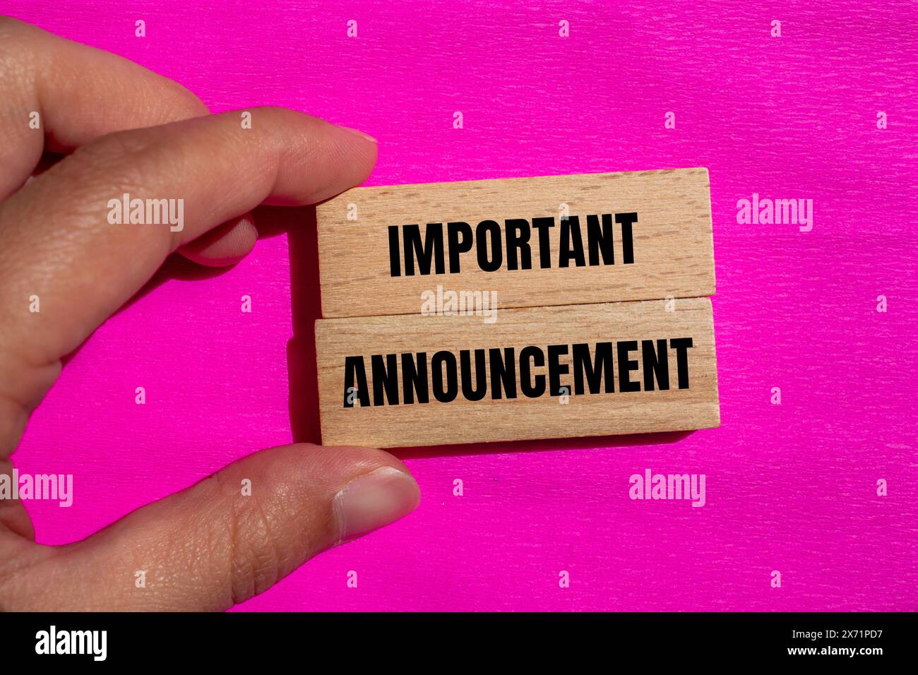 Important announcement words written on wooden blocks with pink ...