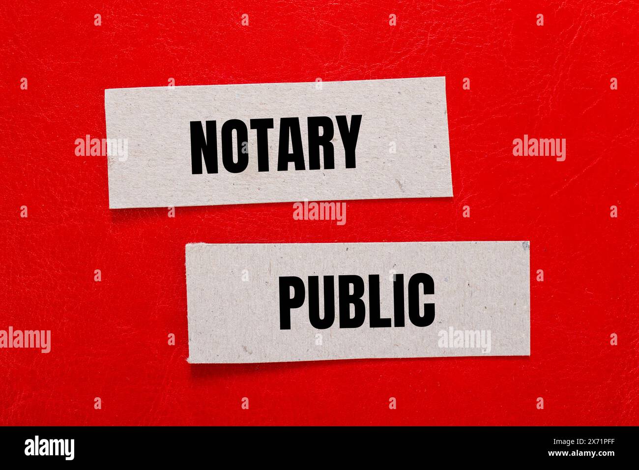 Notary public words written on paper pieces with red background ...
