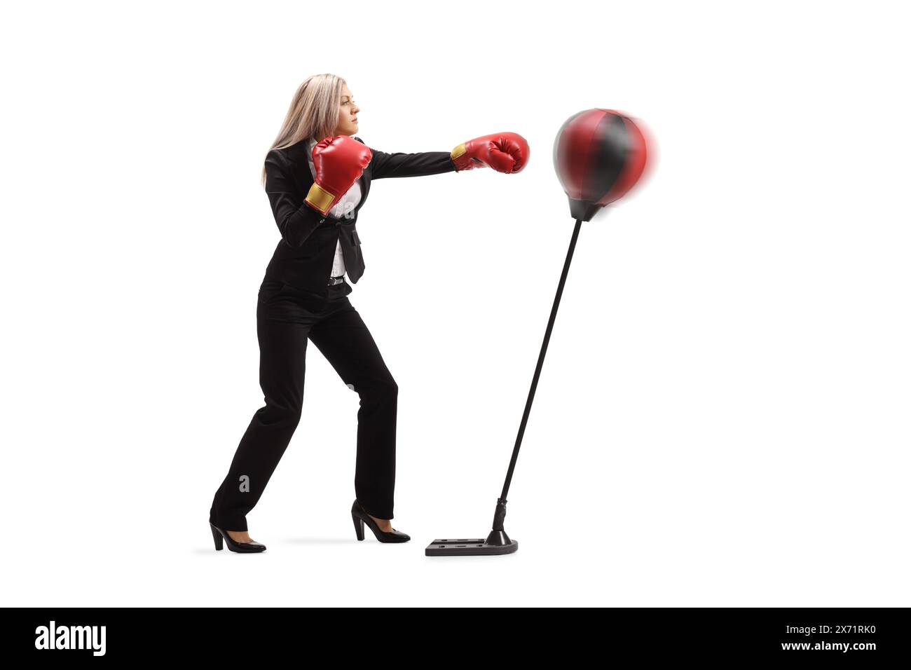 Full length profile shot of a businesswoman punching a boxing stand ...