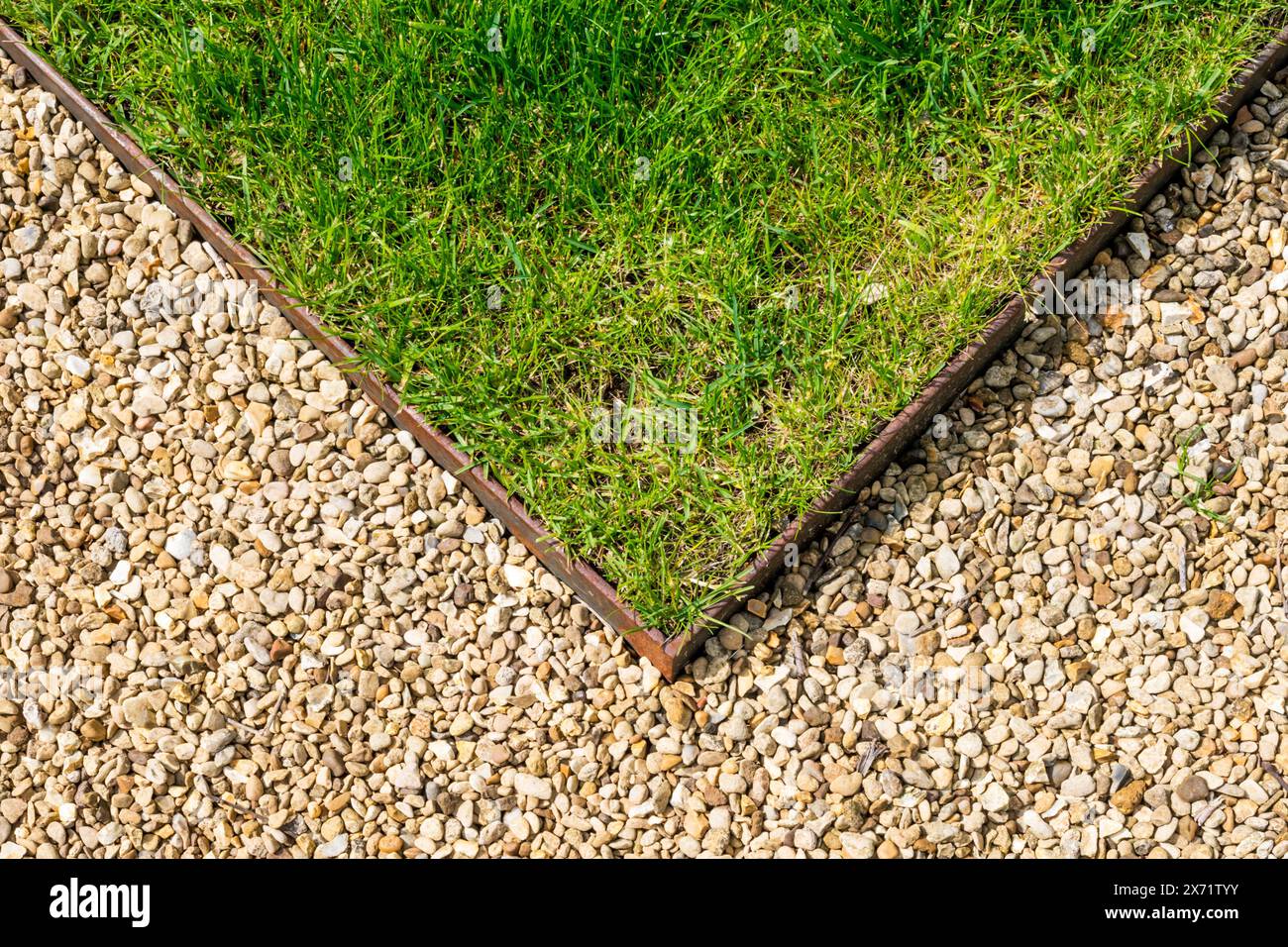 Neat metal lawn edging adjoining a gravel path Stock Photo - Alamy