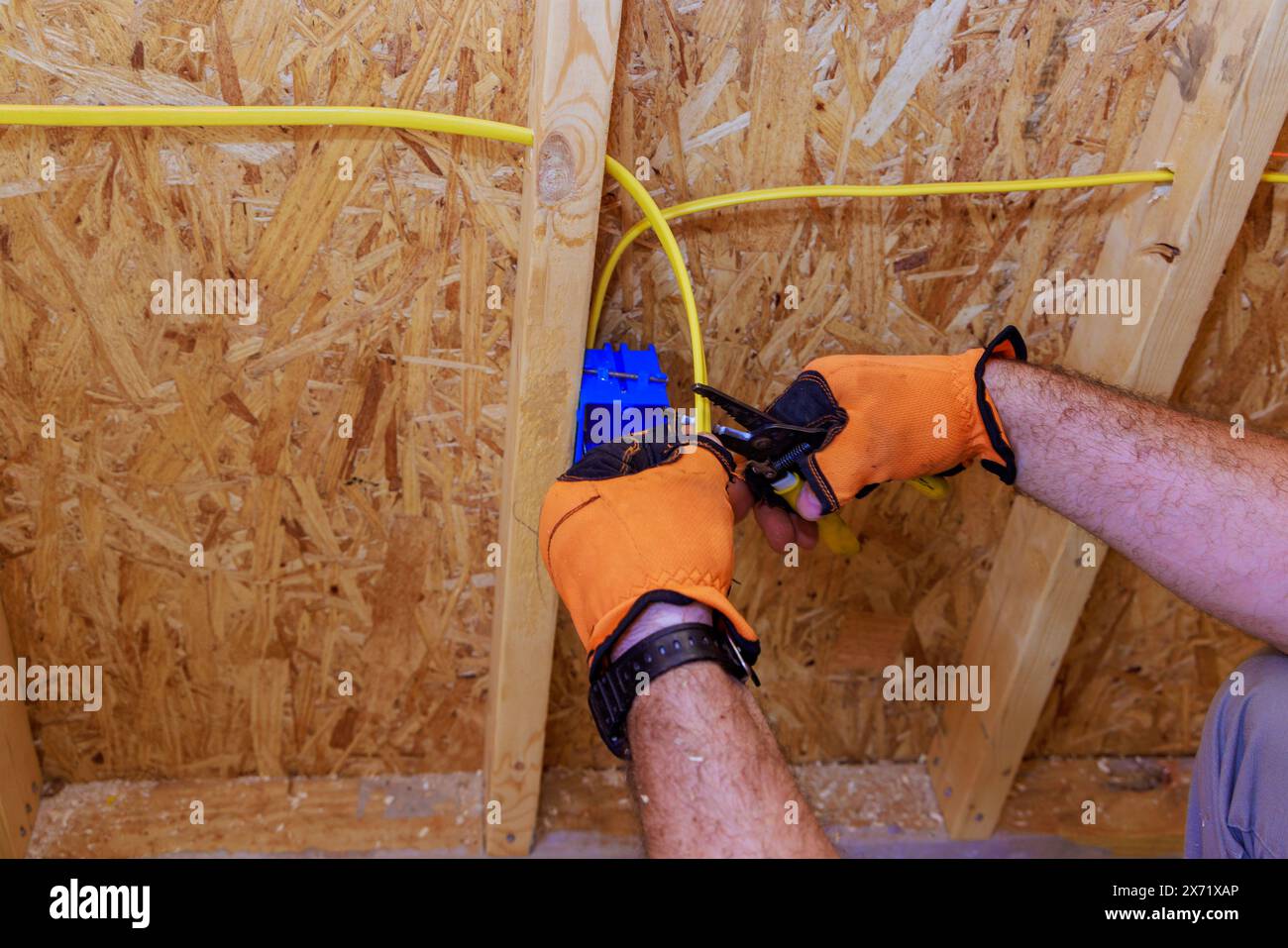 In electrician is installing assembled electrical wires on interior of ...