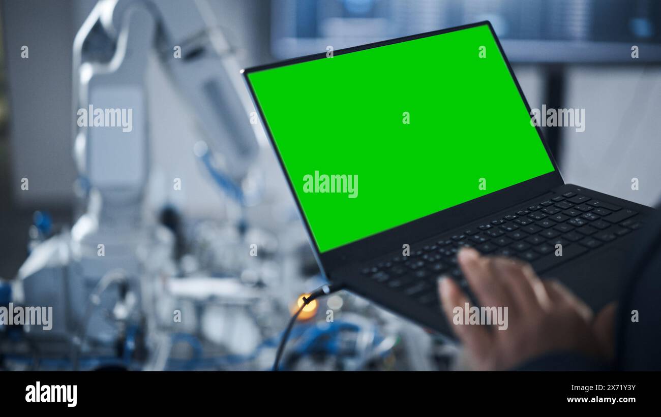 Black Female Engineer Using Laptop with Green Screen Display for ...