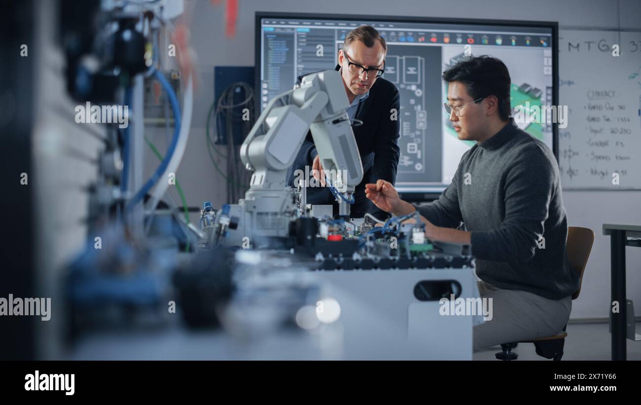 Concentrated Teacher Helping Asian Engineer Student Working with ...