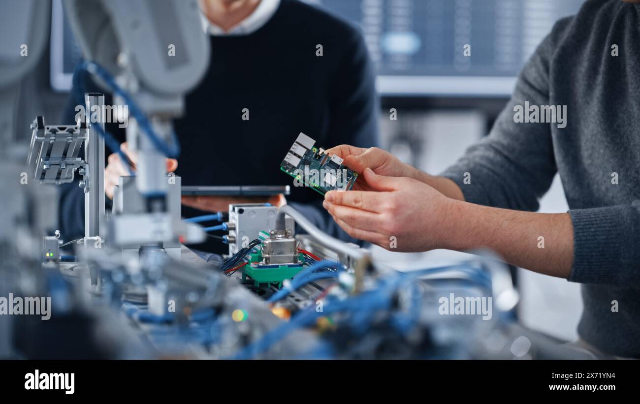 Male Student Typing on Tablet While His Classmate Examining Microchip and Sharing Ideas. Asian ...