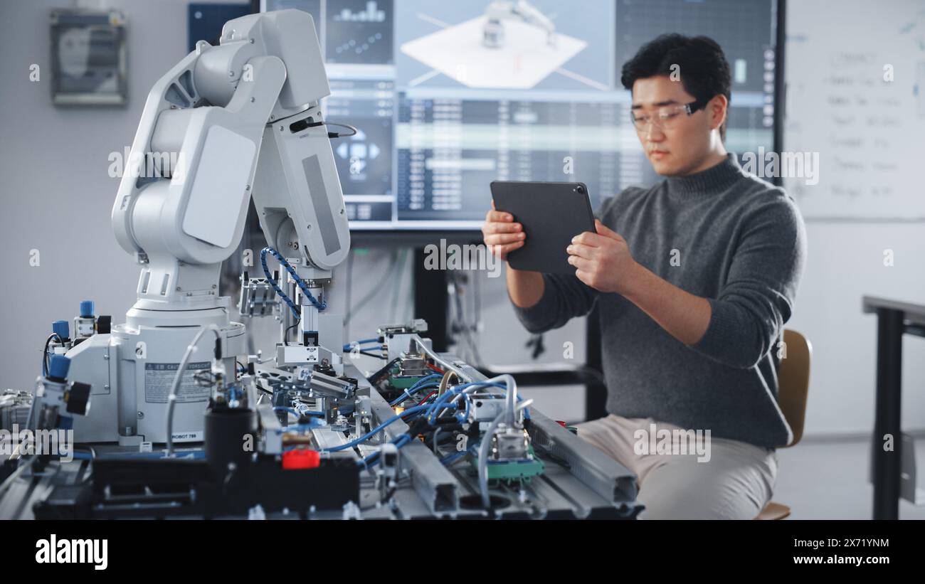 Student Using Tablet to Controll Robotic Hand. Bionic Arm Moving in Different Directions During ...