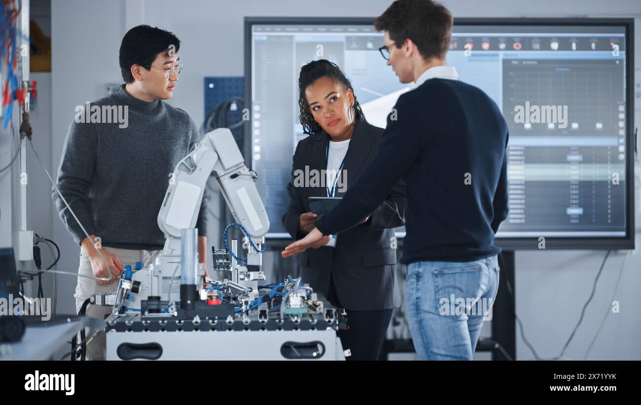 Black Teacher with Tablet and Two Diverse Students Analyse and Discuss Futuristic Robotic Arm ...