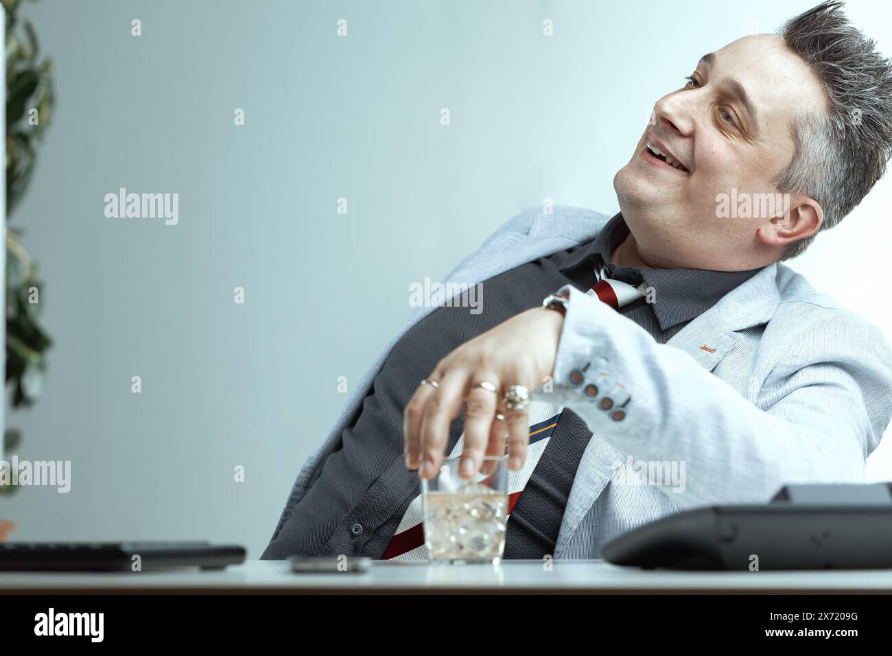 Middle-aged man in light gray blazer, dark gray shirt, and striped tie ...
