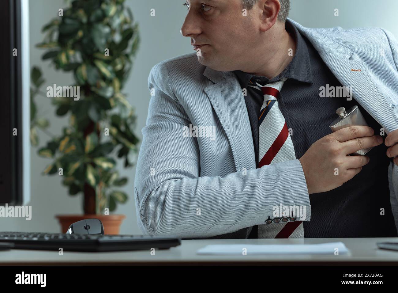 Discreet man in a light gray suit jacket, dark gray shirt, and striped ...