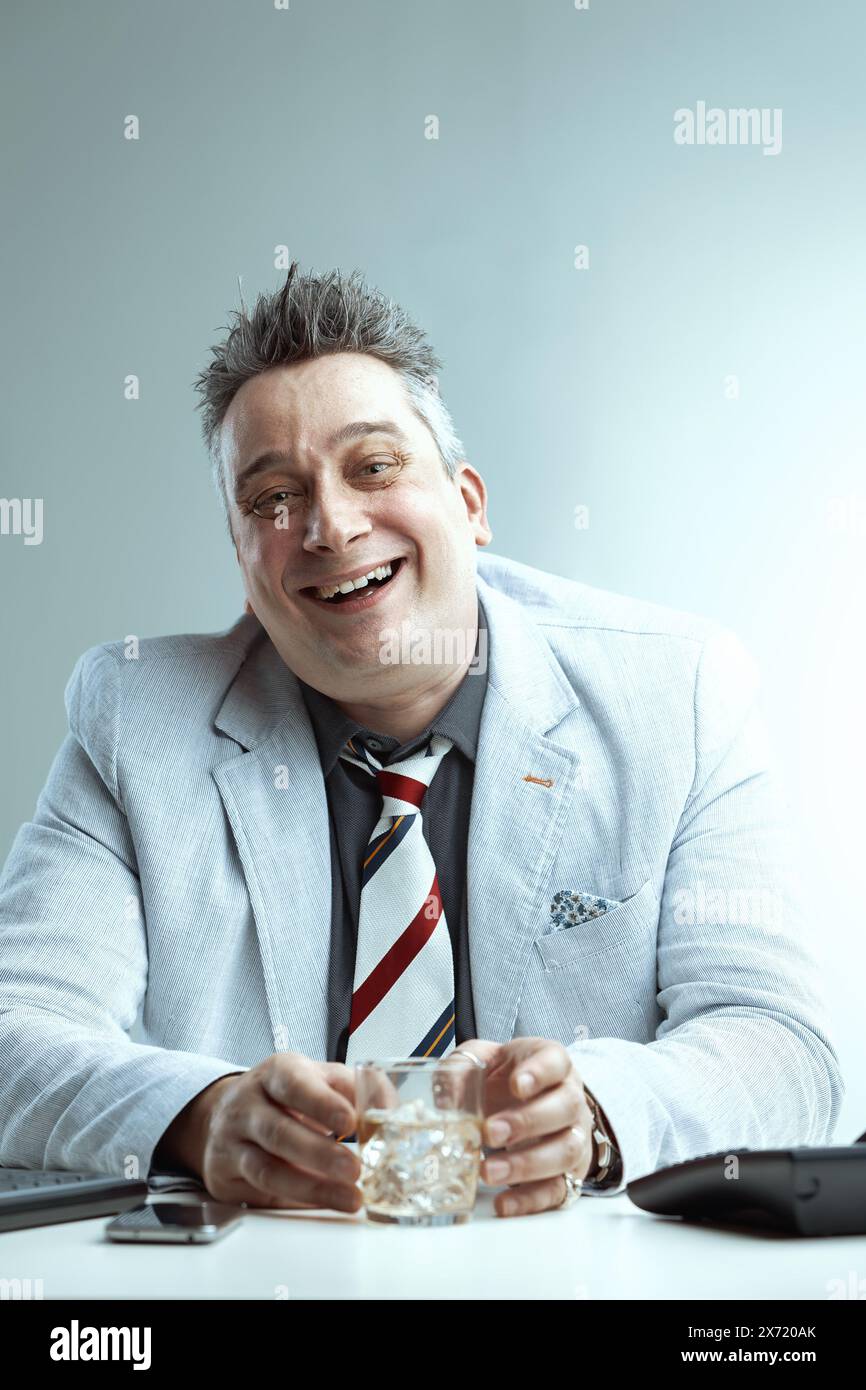 Light gray-haired man in a light gray blazer, dark gray shirt, and ...