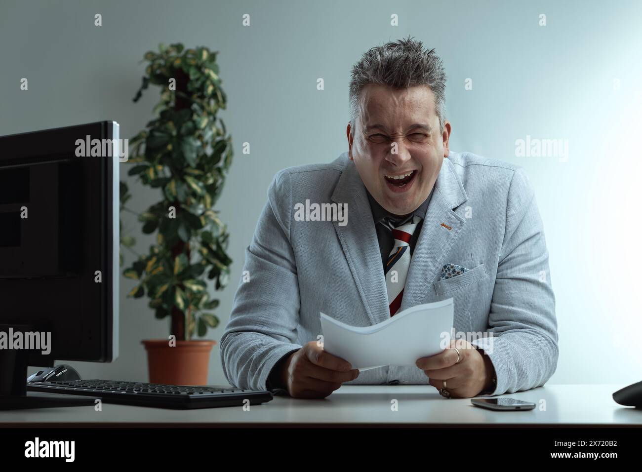 middle-aged man in a light suit and striped tie holds documents ...