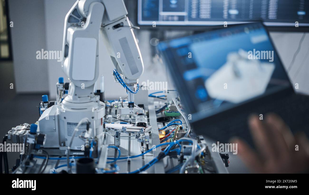 Black Female Engineer Using Laptop for Programming Robotic Arm At the ...