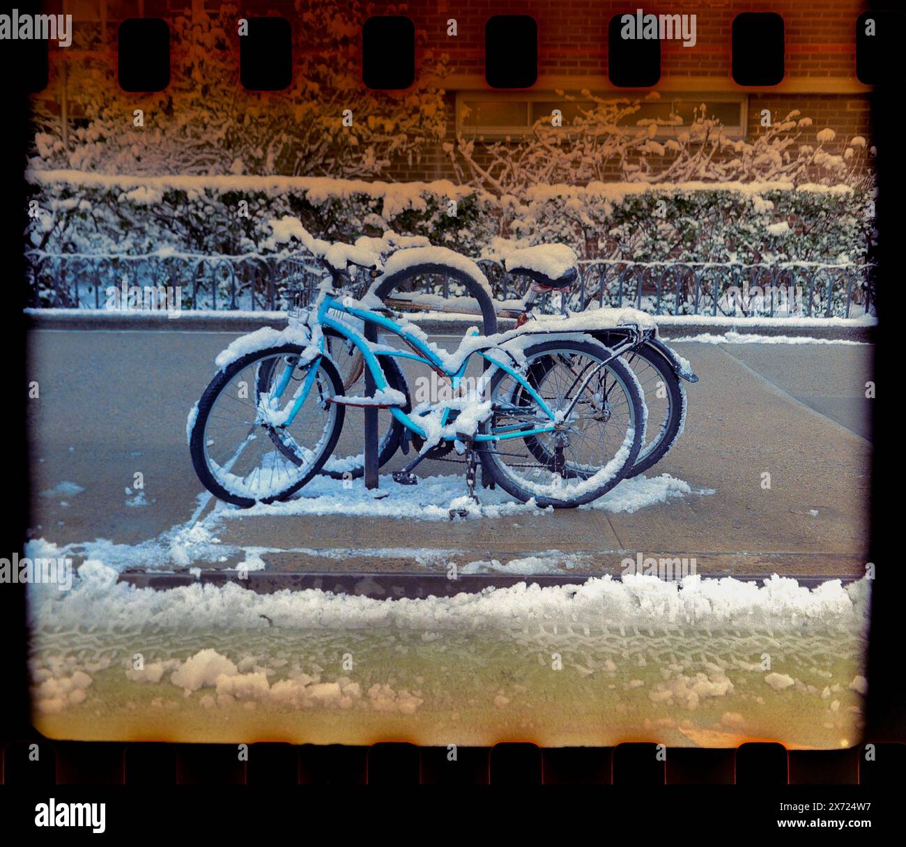 A snow encrusted bicycle chained to a bike rack in the Chelsea ...