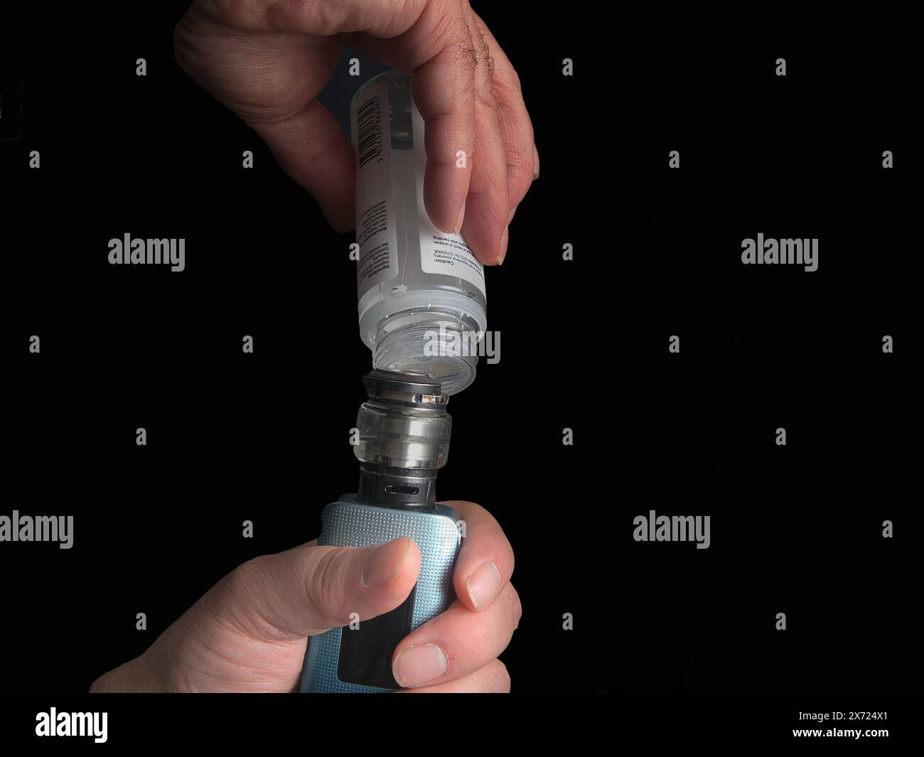 Hands illustrating refilling a smoking vape on a black background Stock ...