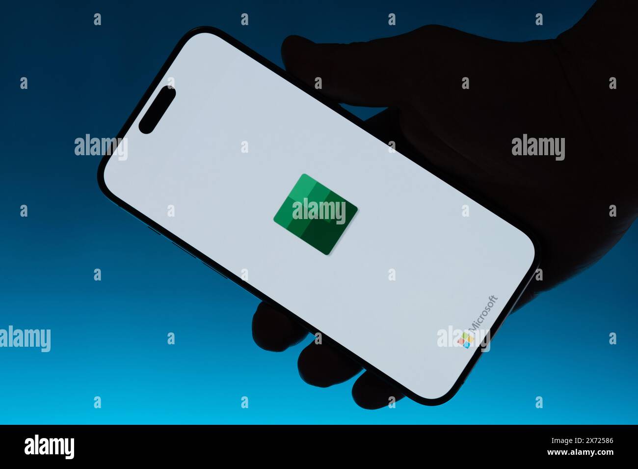 New York, USA - May 6, 2024: Open Microsoft excel app on smartphone in hand isolated blue ...