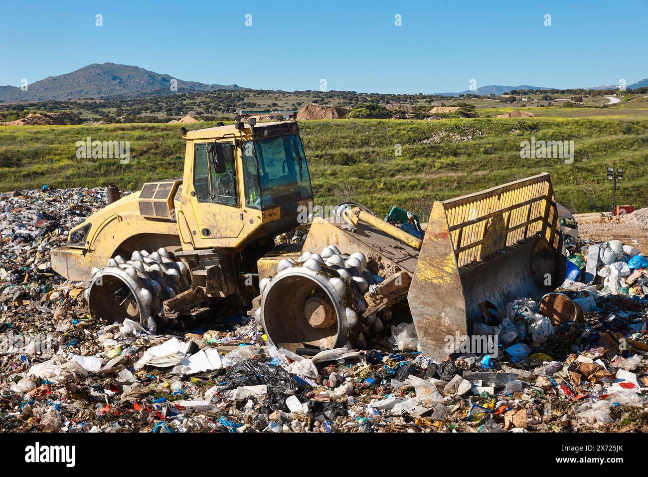 Heavy machinery shredding garbage in an open air landfill. Waste Stock ...